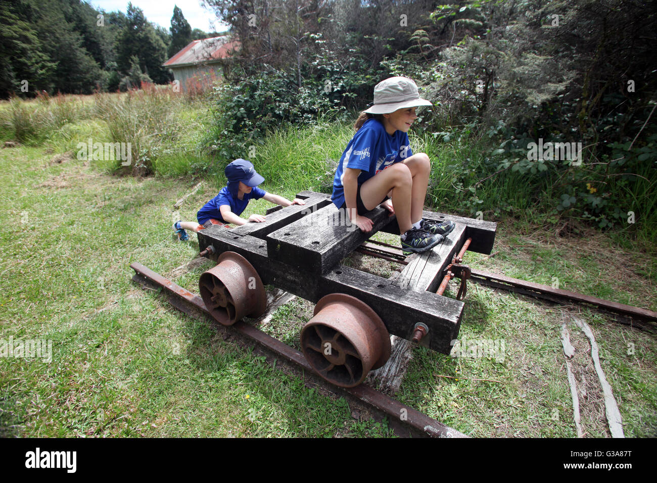 Young boy and girl playing with disused mining equipment while walking ...