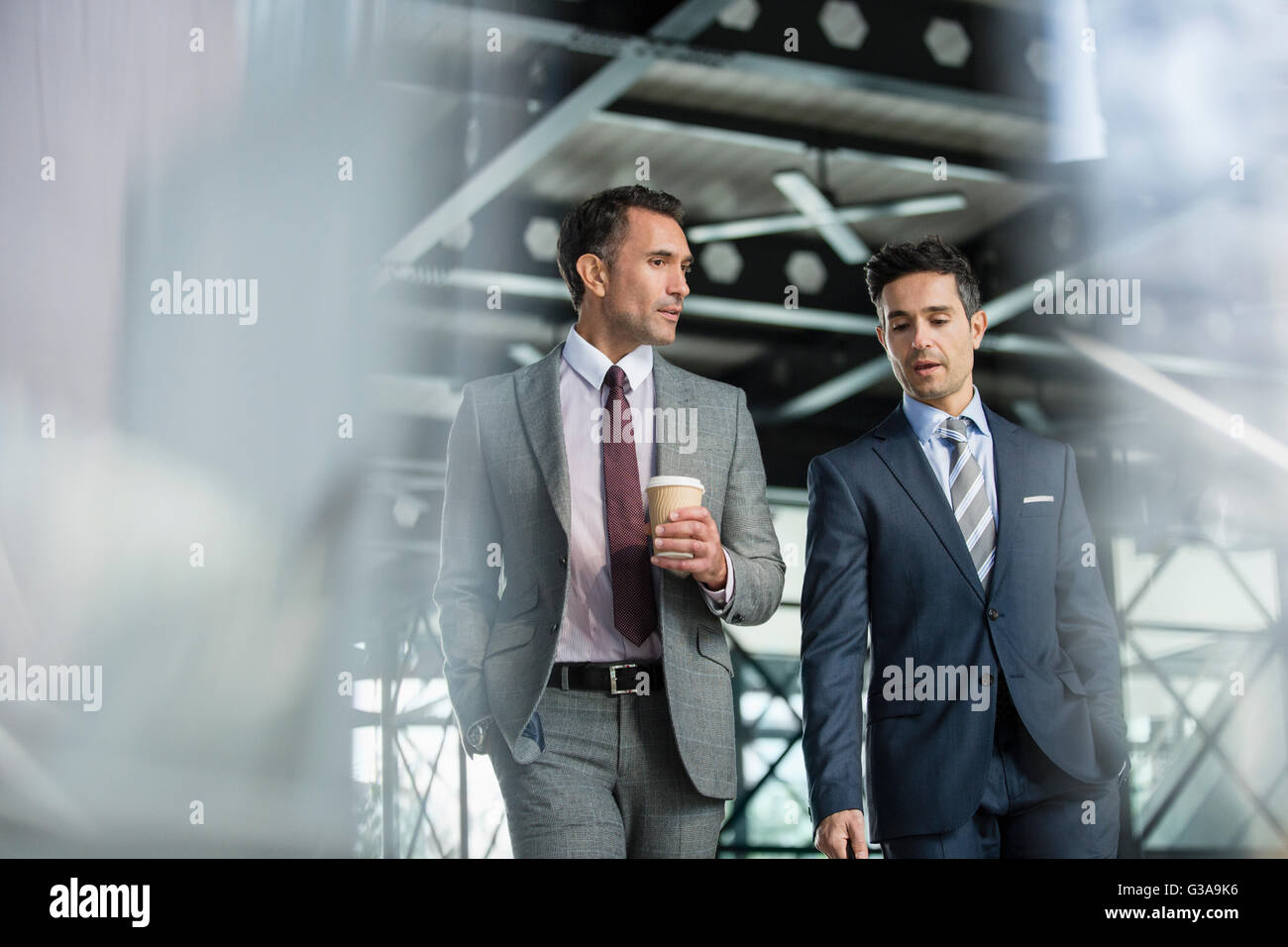 Corporate businessmen walking with coffee Stock Photo - Alamy