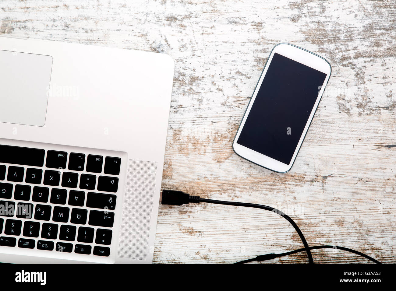 Smartphone and Laptop on a wooden Desktop Stock Photo - Alamy