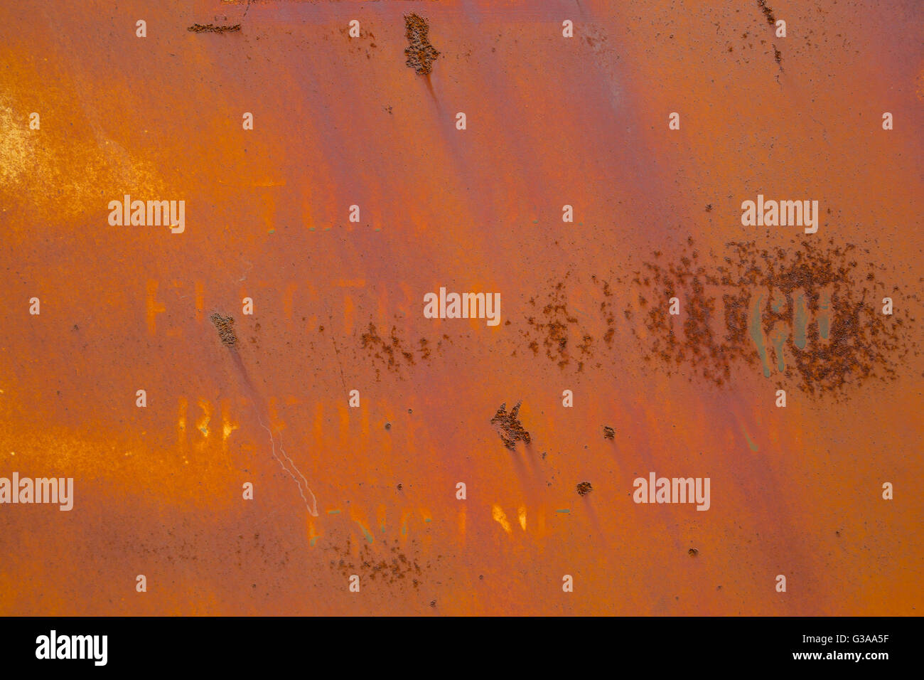 detail of a heavily rusted steel panel with remnants of stenciled words ...