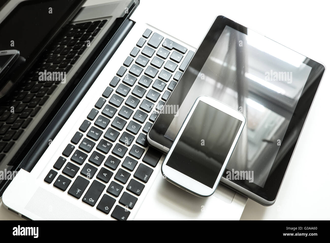 A smartphone, a laptop computer and a Tablet PC together on a desktop ...