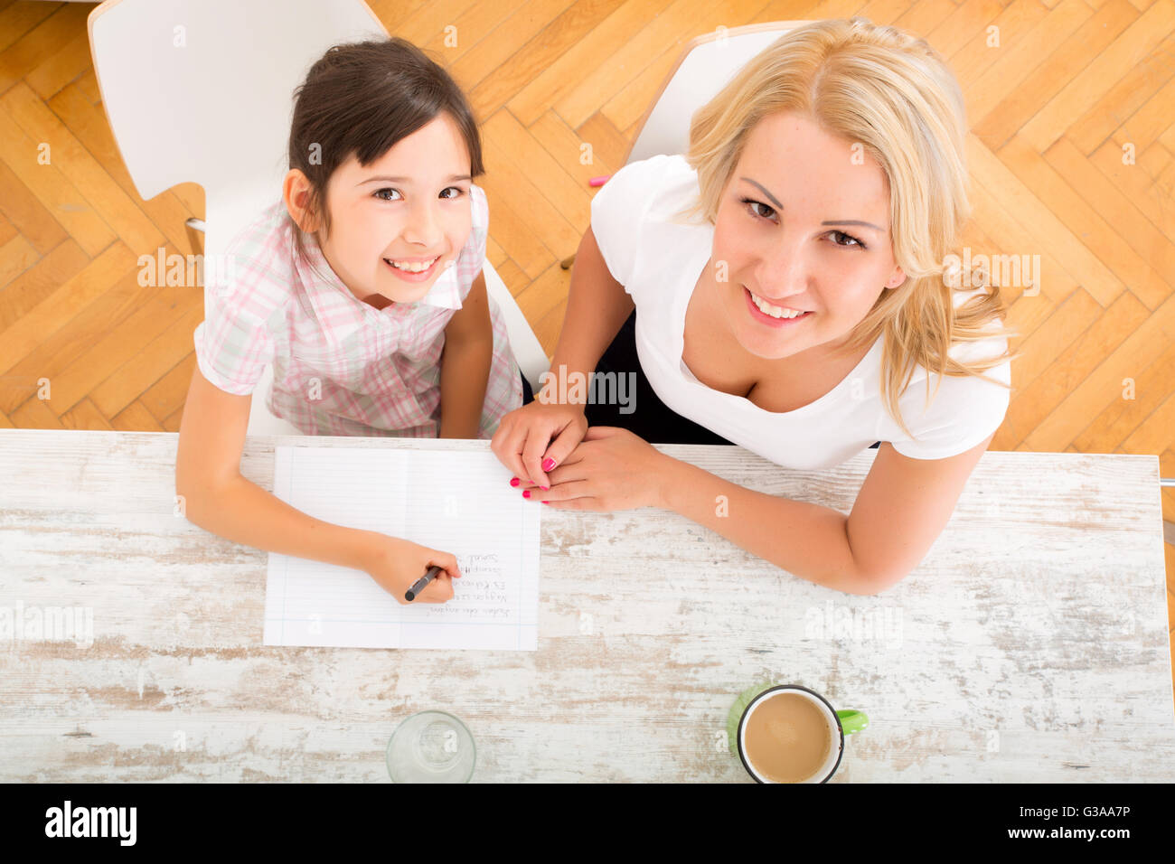 A mother helping her daughter with the homework seen from above Stock ...