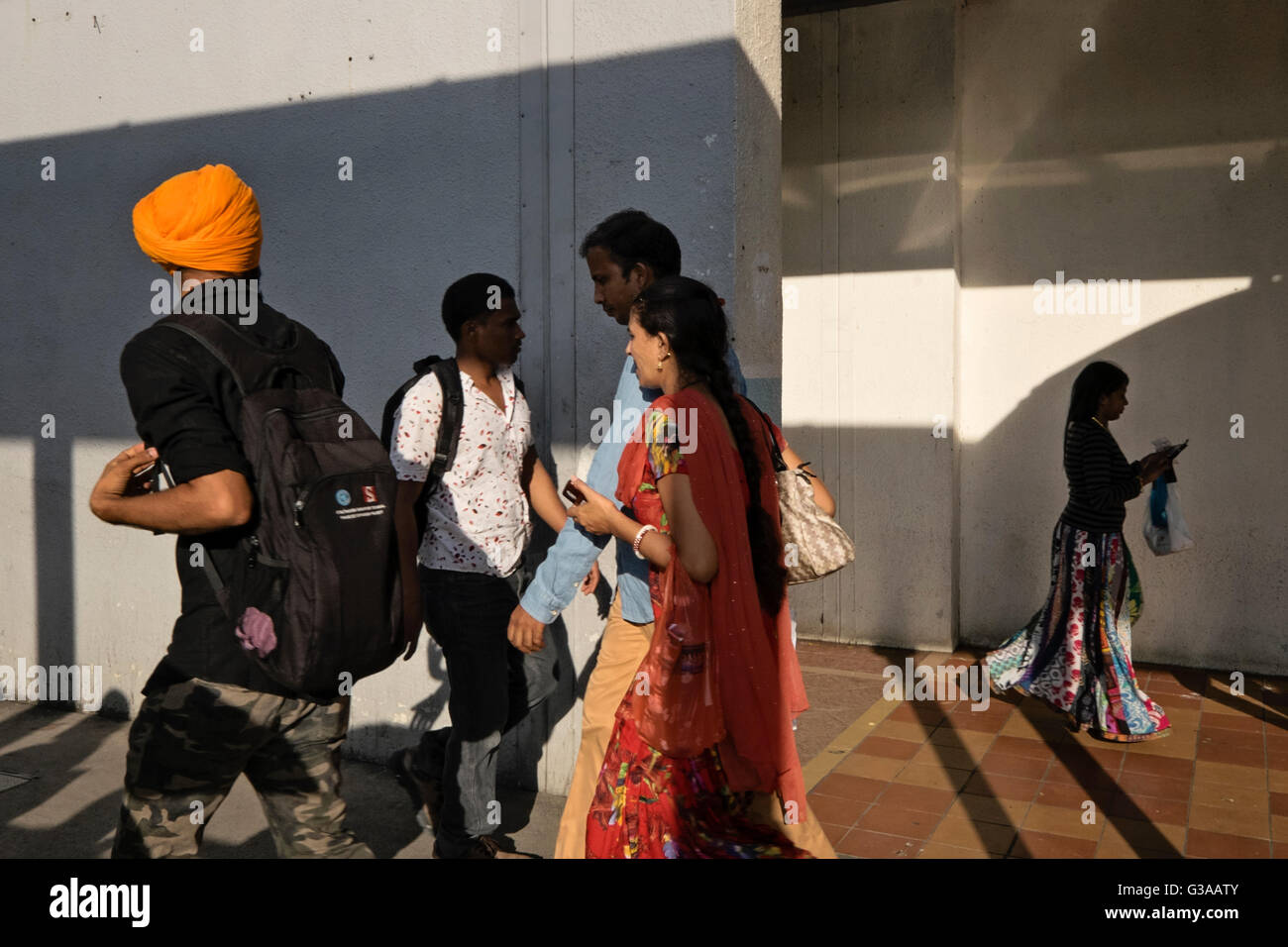 Commuters at the entrance of the Little India MRT Station in Singapore ...