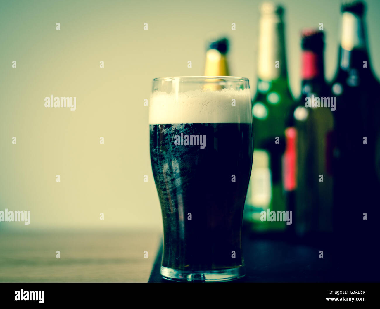 Pint of craft beer on bar, with beer bottles Stock Photo - Alamy