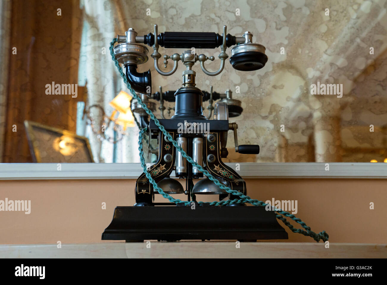 An old black phone with green cord in front of a big mirror Stock Photo ...