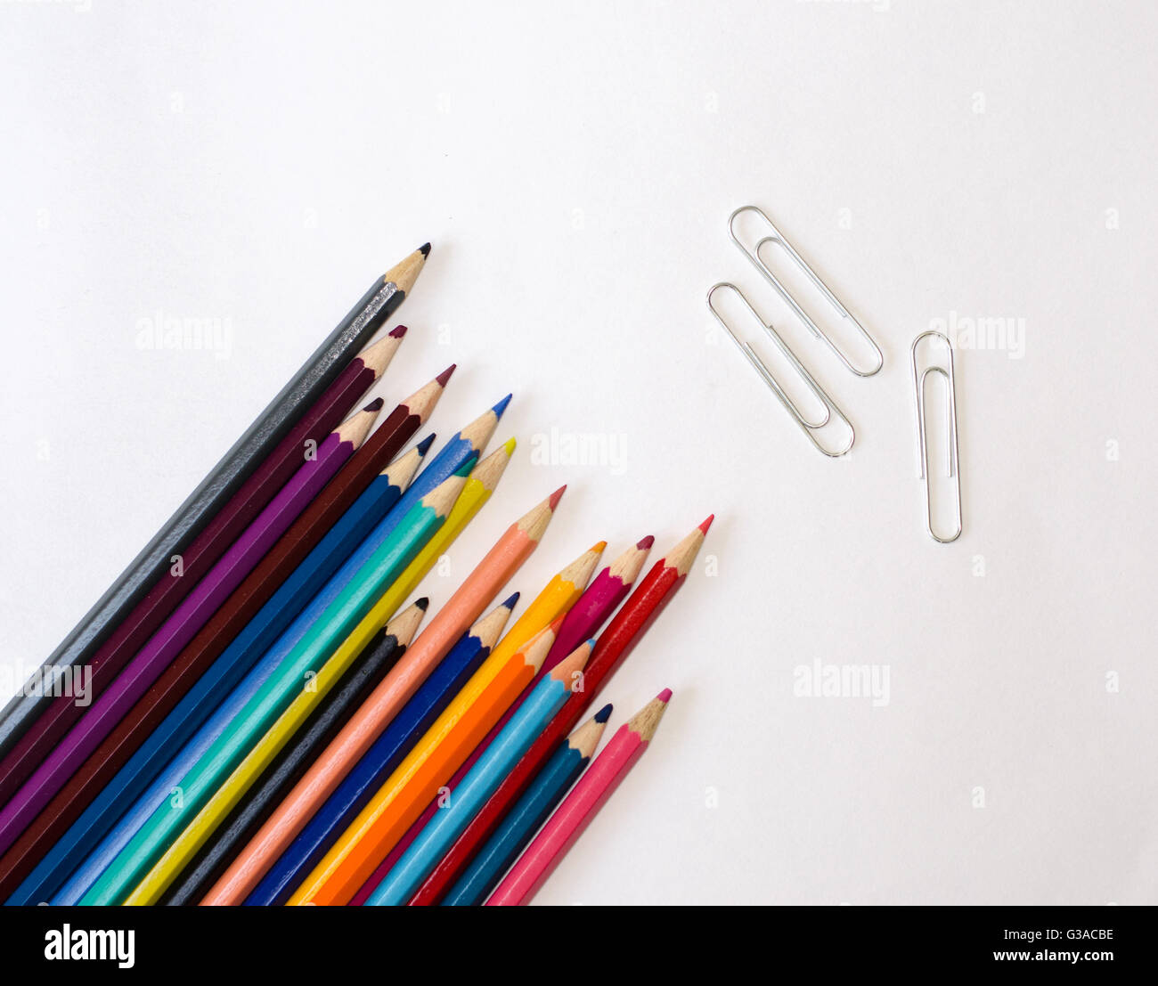 Colourful pencils and paper clips, white office desk Stock Photo - Alamy