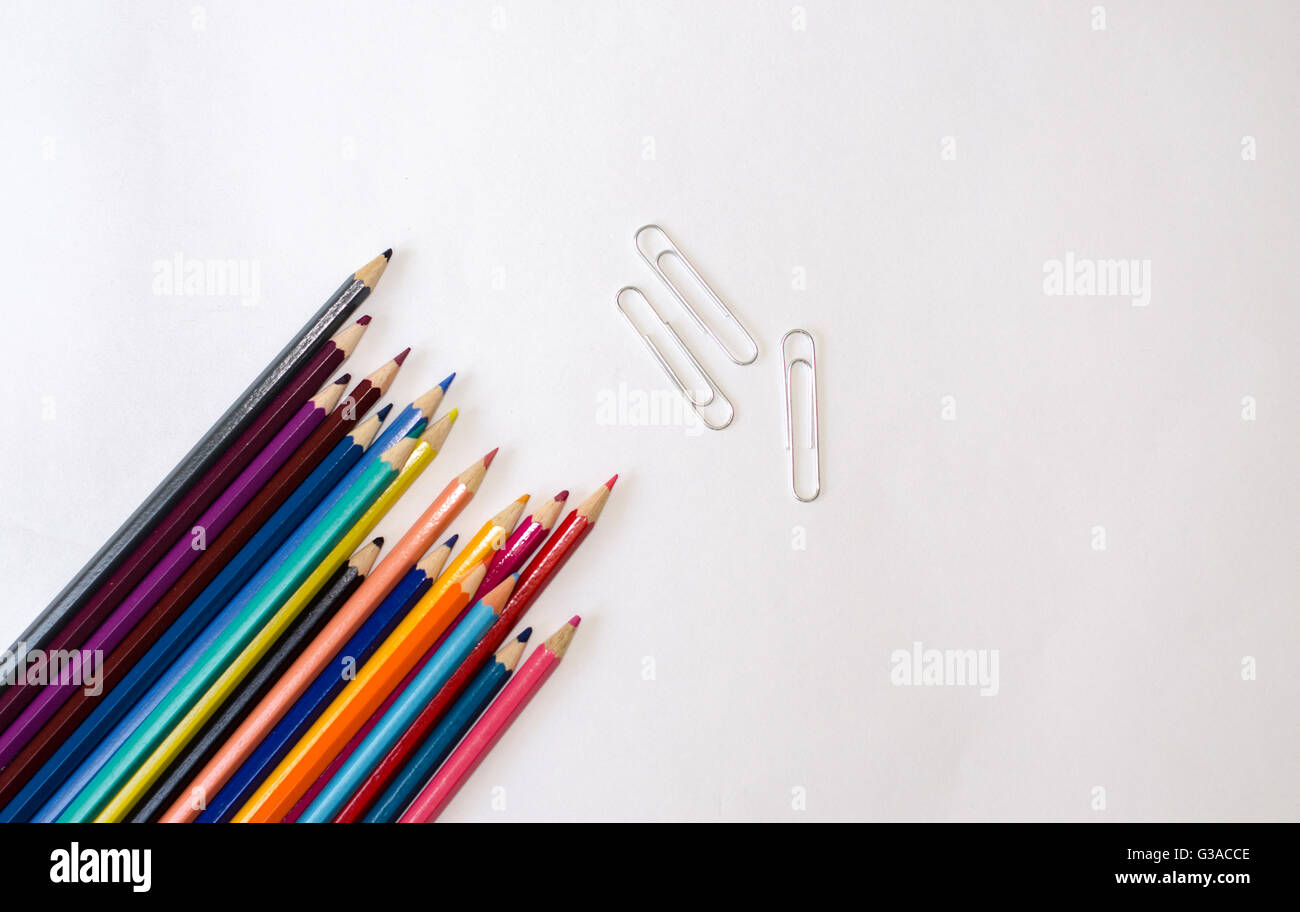 Colourful pencils and paper clips, white office desk Stock Photo - Alamy