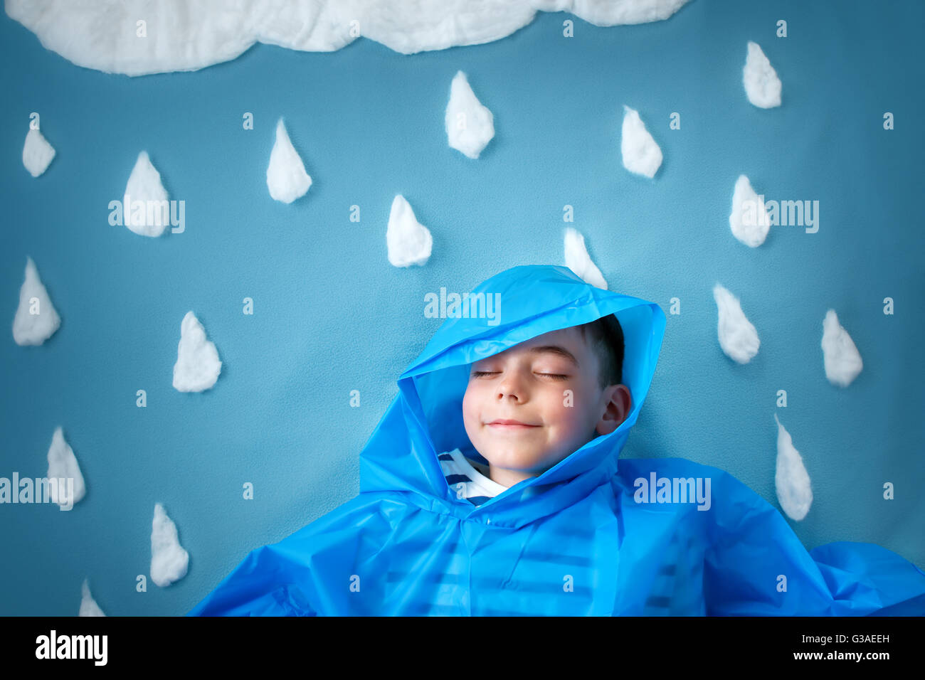 boy on blue background in coat with drop shapes Stock Photo - Alamy
