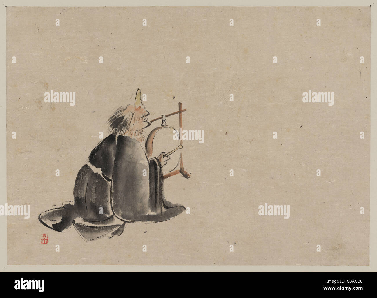 A monk wearing a mask(?) with a horn, sitting on the ground Stock Photo ...