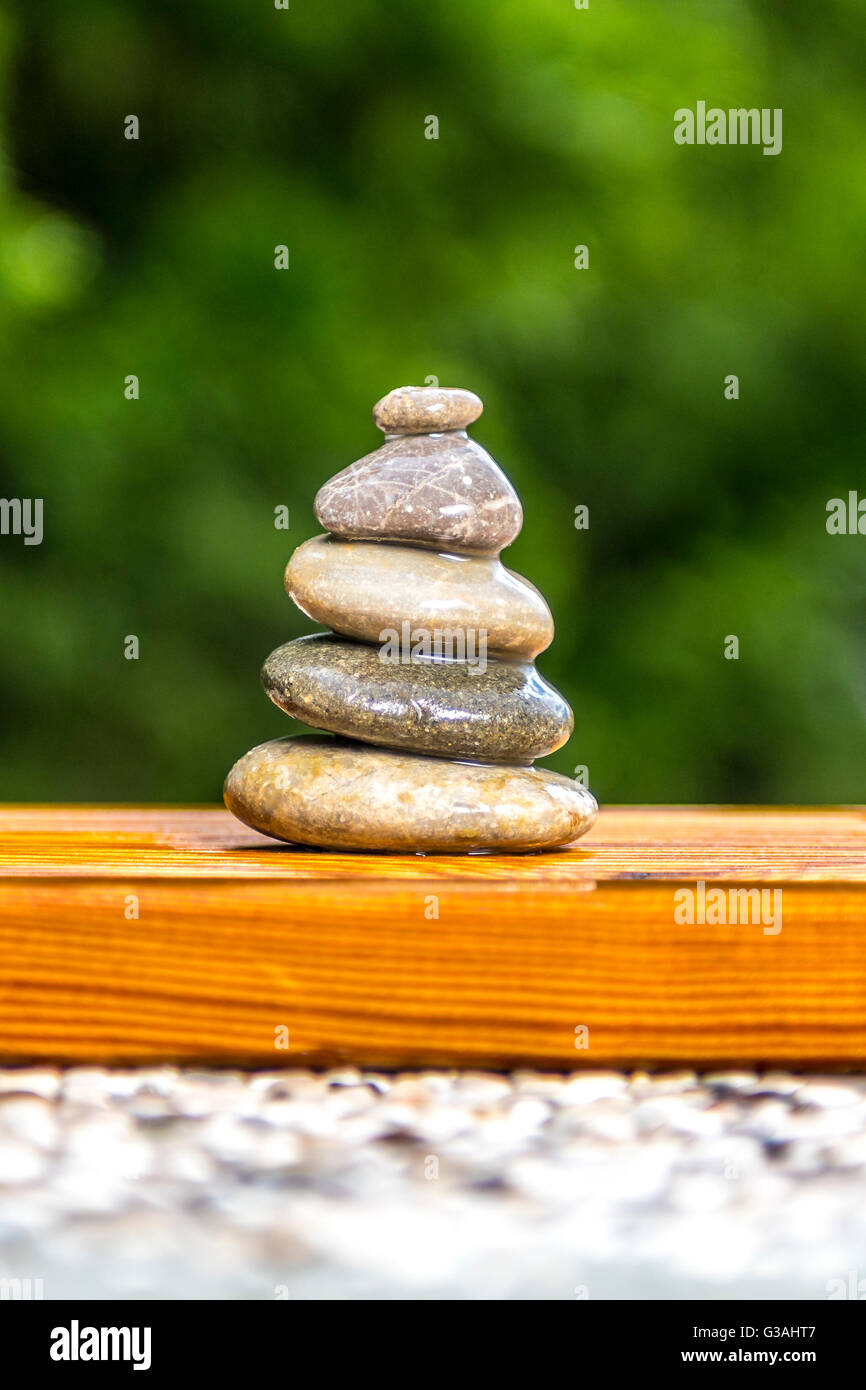 Wet zen stones on wood with green background Stock Photo - Alamy