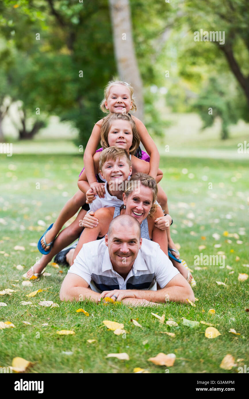 A family creating a totem pole picture by climbing on top of each other ...