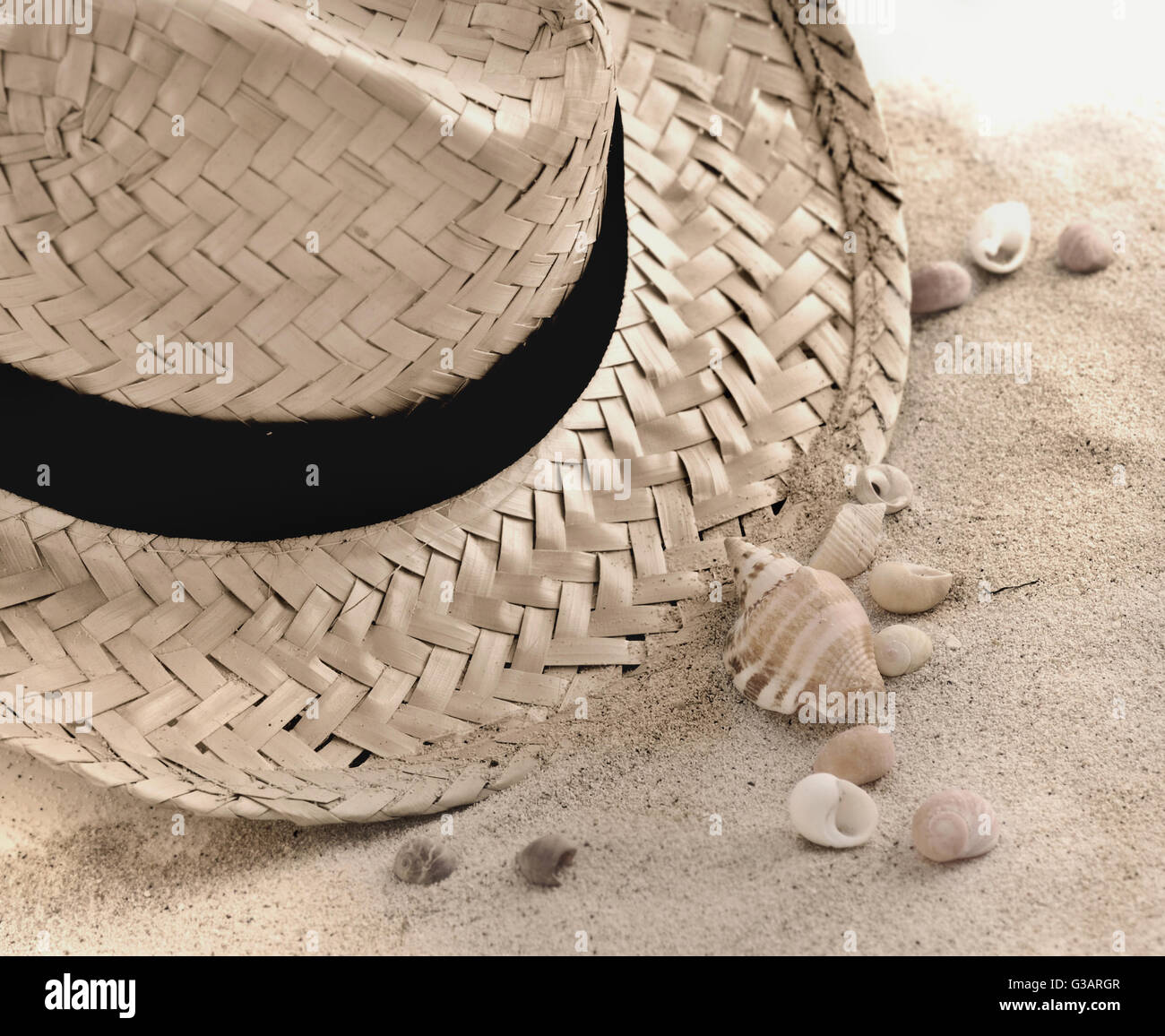 close on straw hat in the sand and seashells Stock Photo - Alamy
