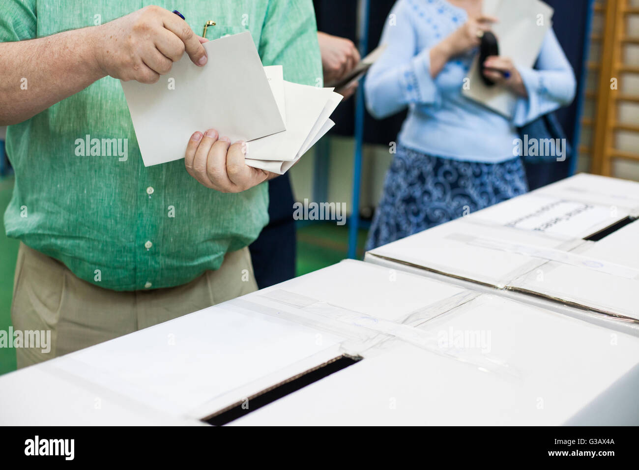 A person prepares to cast a ballot at a polling station during voting ...
