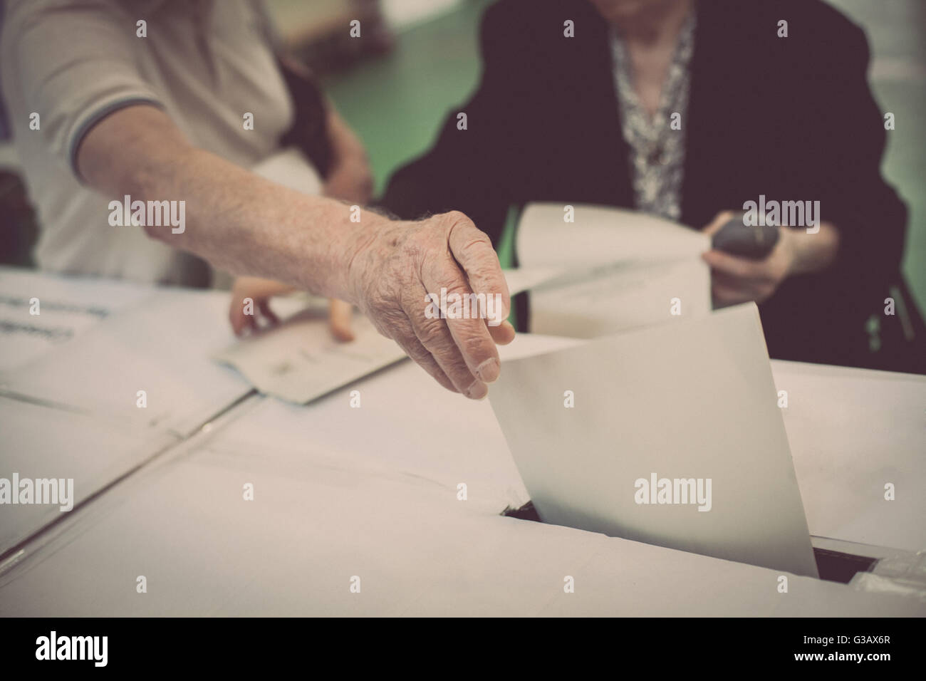 Hand of a person casting a ballot at a polling station during voting ...