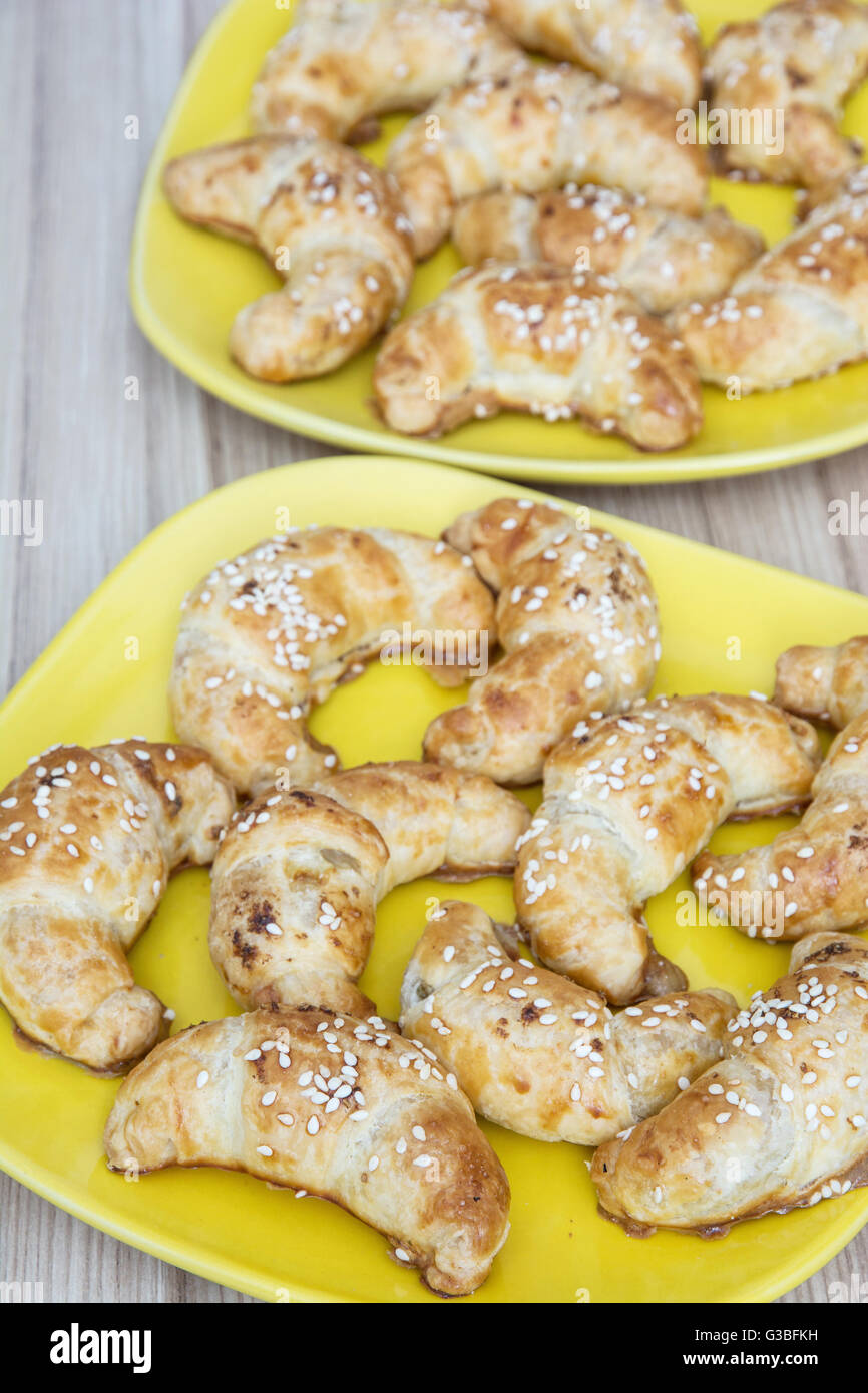 Tasty sesame pastries on two yellow plates. Food theme. Crispy pastry ...