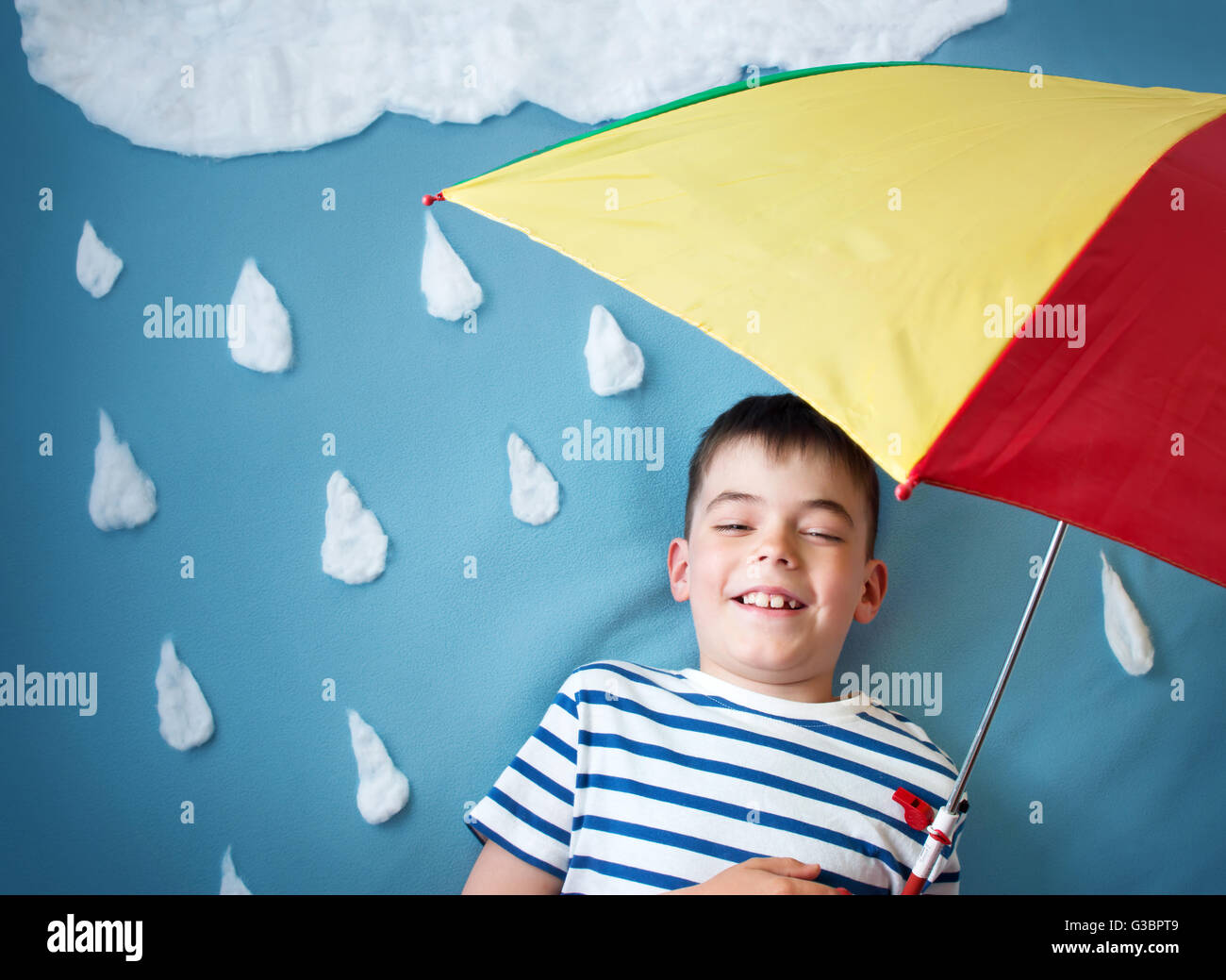 Little boy on blue background in coat with drop shapes Stock Photo - Alamy