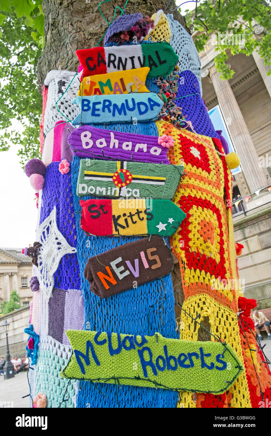 The trunk of a tree covered with a patchwork of coloured bright knitted ...