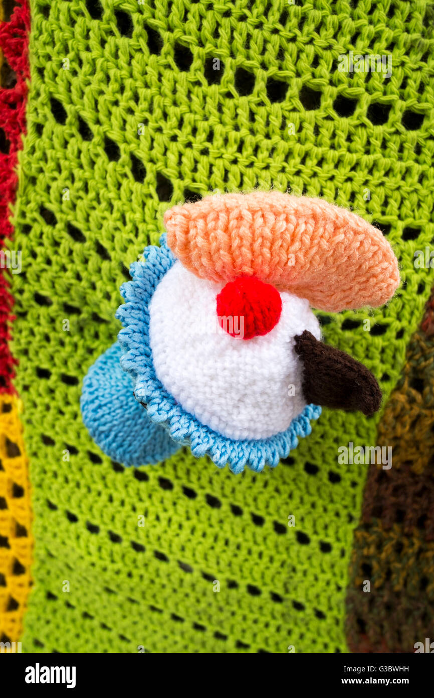 The trunk of a tree covered with a patchwork of coloured bright knitted ...