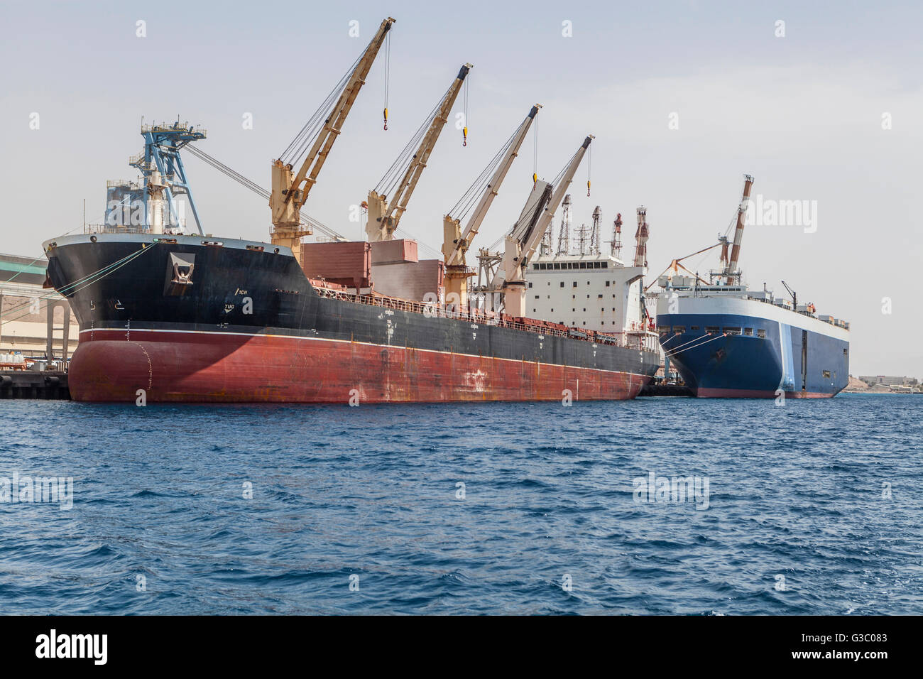 Blue ship following the working ship on water Stock Photo - Alamy