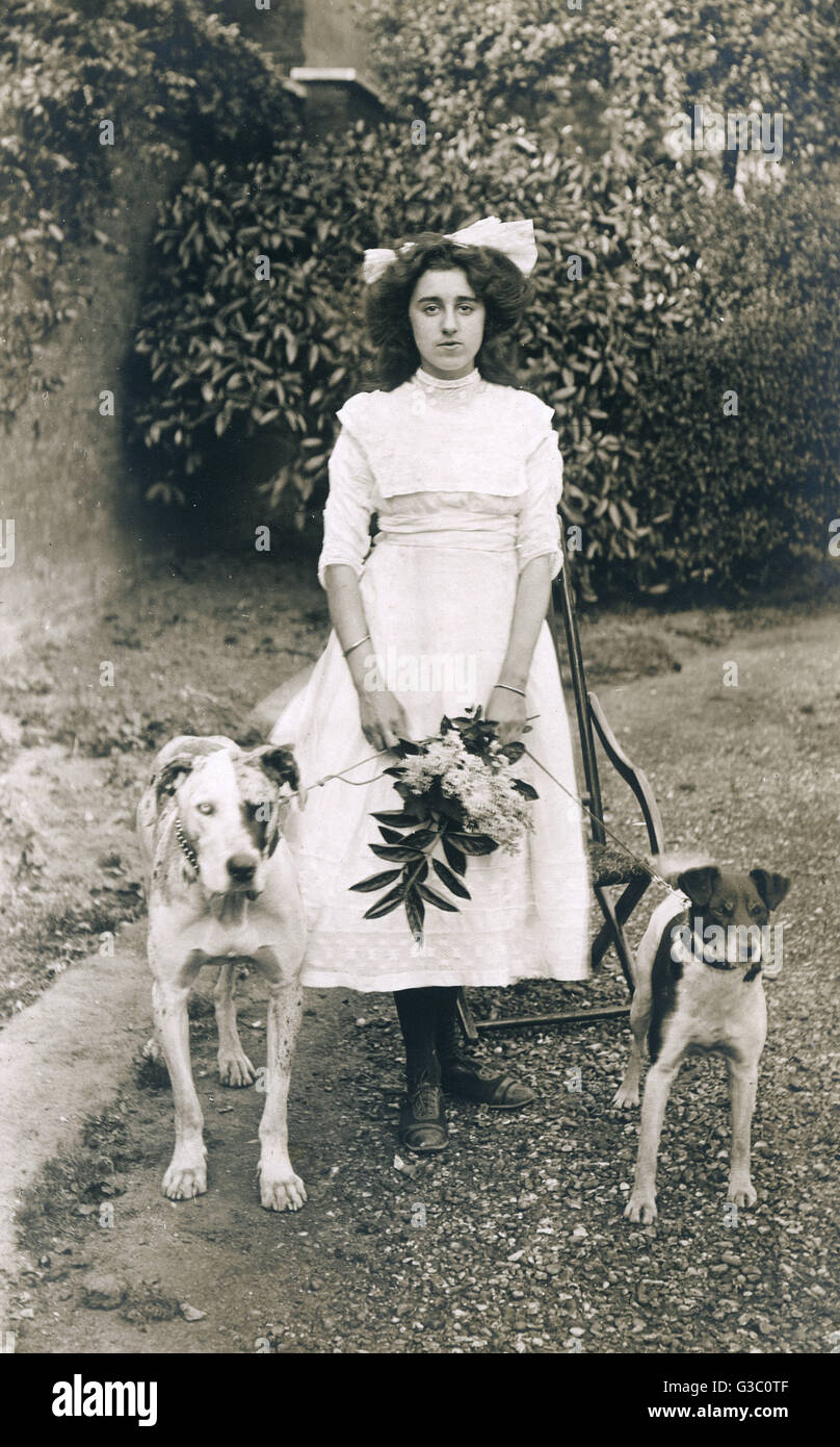 Young woman with two dogs in a garden Stock Photo - Alamy