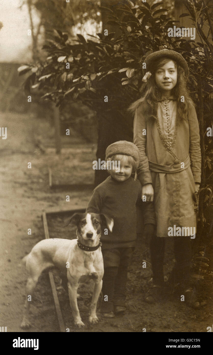 Two children with Jack Russell terrier in a garden Stock Photo - Alamy
