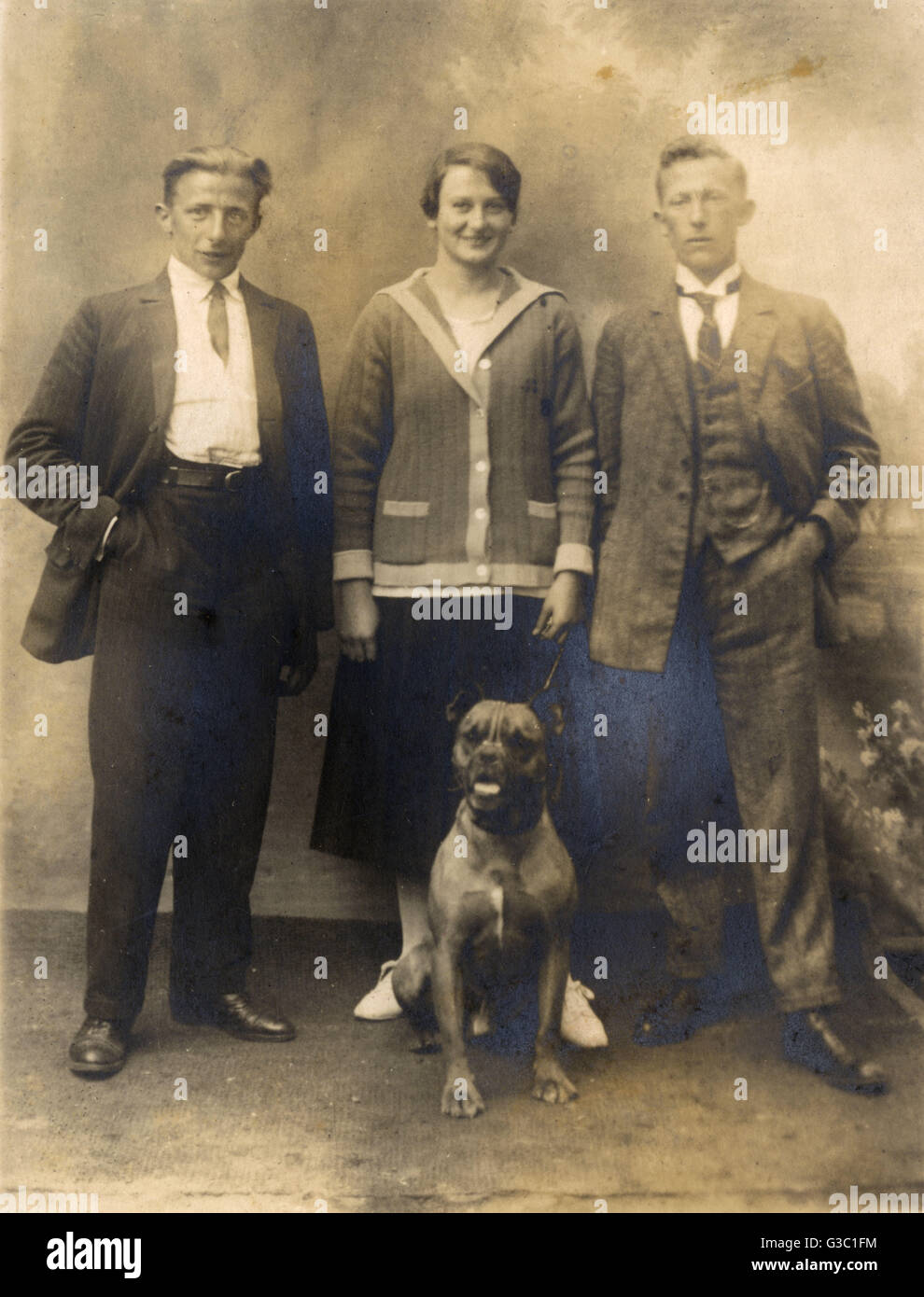Studio portrait, three people with boxer dog Stock Photo - Alamy