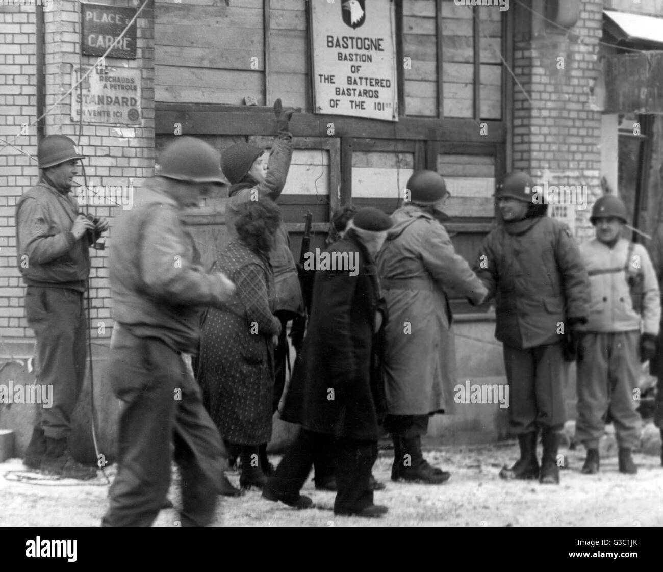 American soldiers and local residents in a street in Bastogne, the ...