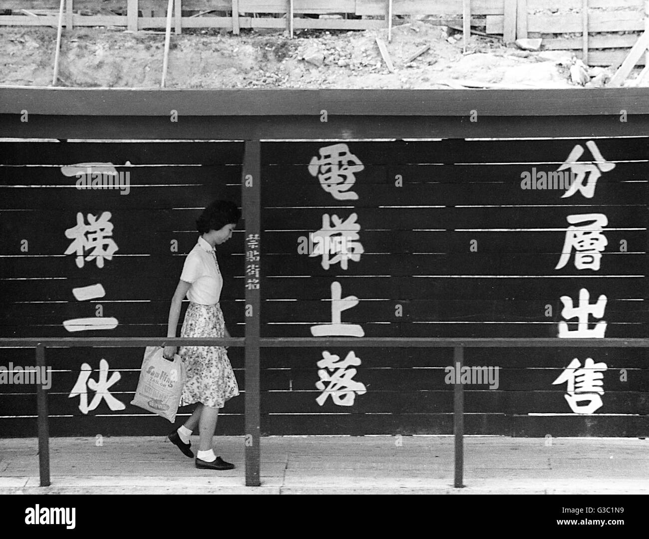 Woman passing lettered hoarding in kowloon hi-res stock photography and ...