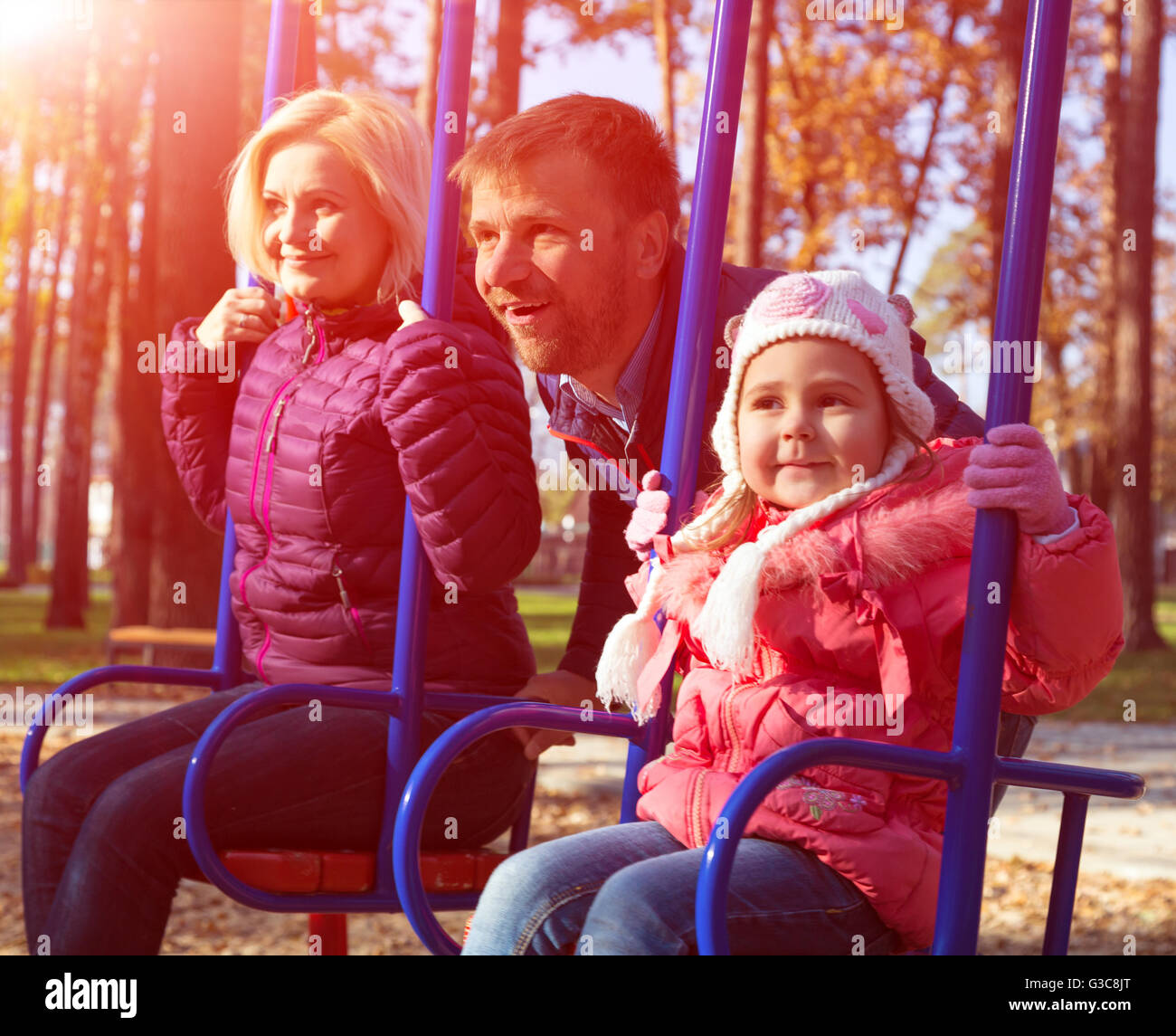 Young Jolly Family Having Fun on Kids Seesaw in Park Stock Photo - Alamy