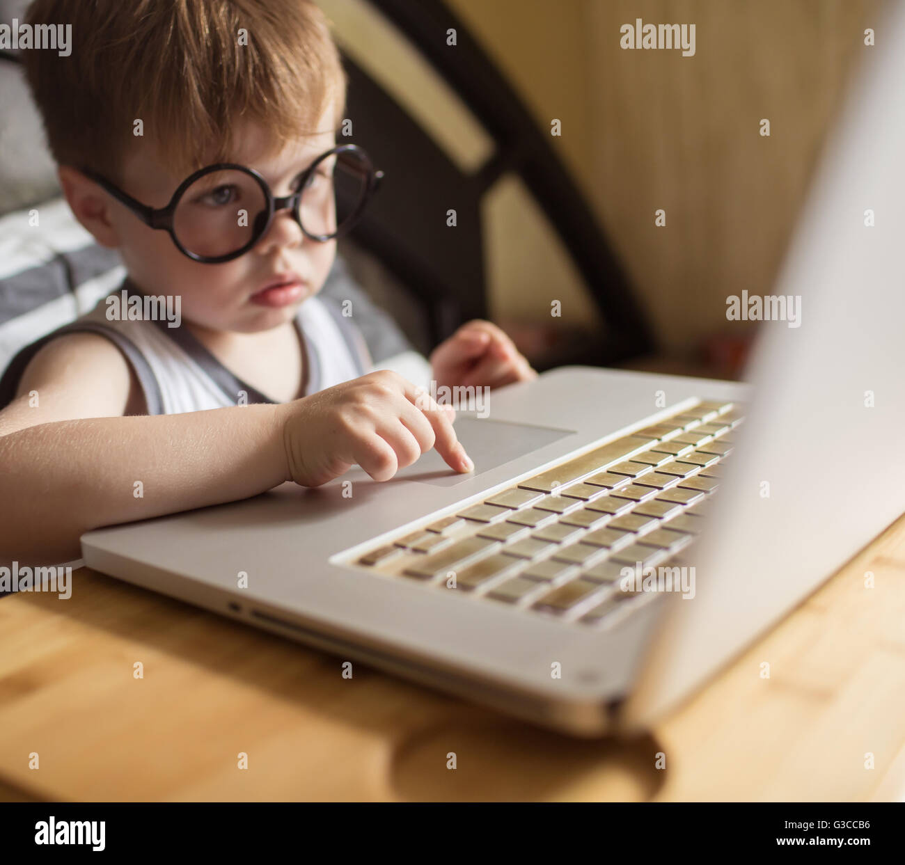Toddler boy laying on the bed with laptop Stock Photo - Alamy