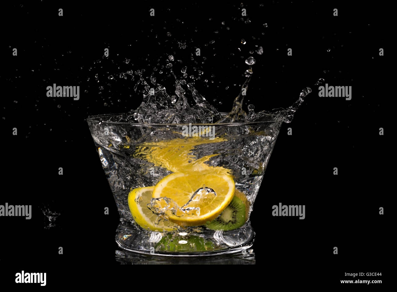 Fruit splashing in water on a black background Stock Photo - Alamy