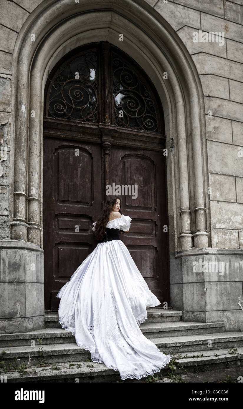 Mysterious woman in Victorian dress with old doors Stock Photo - Alamy