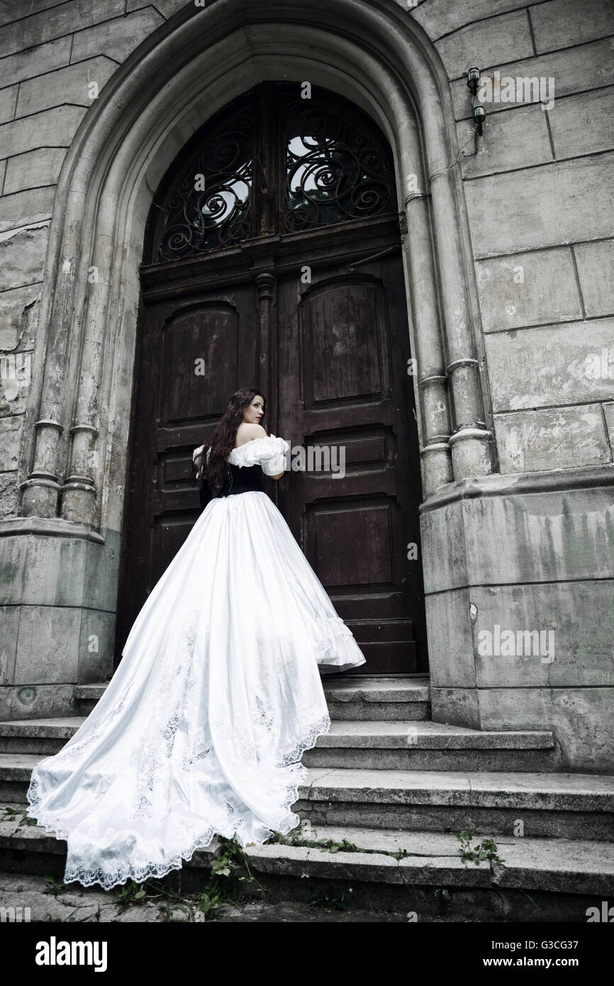 Mysterious woman in Victorian dress with old doors Stock Photo - Alamy