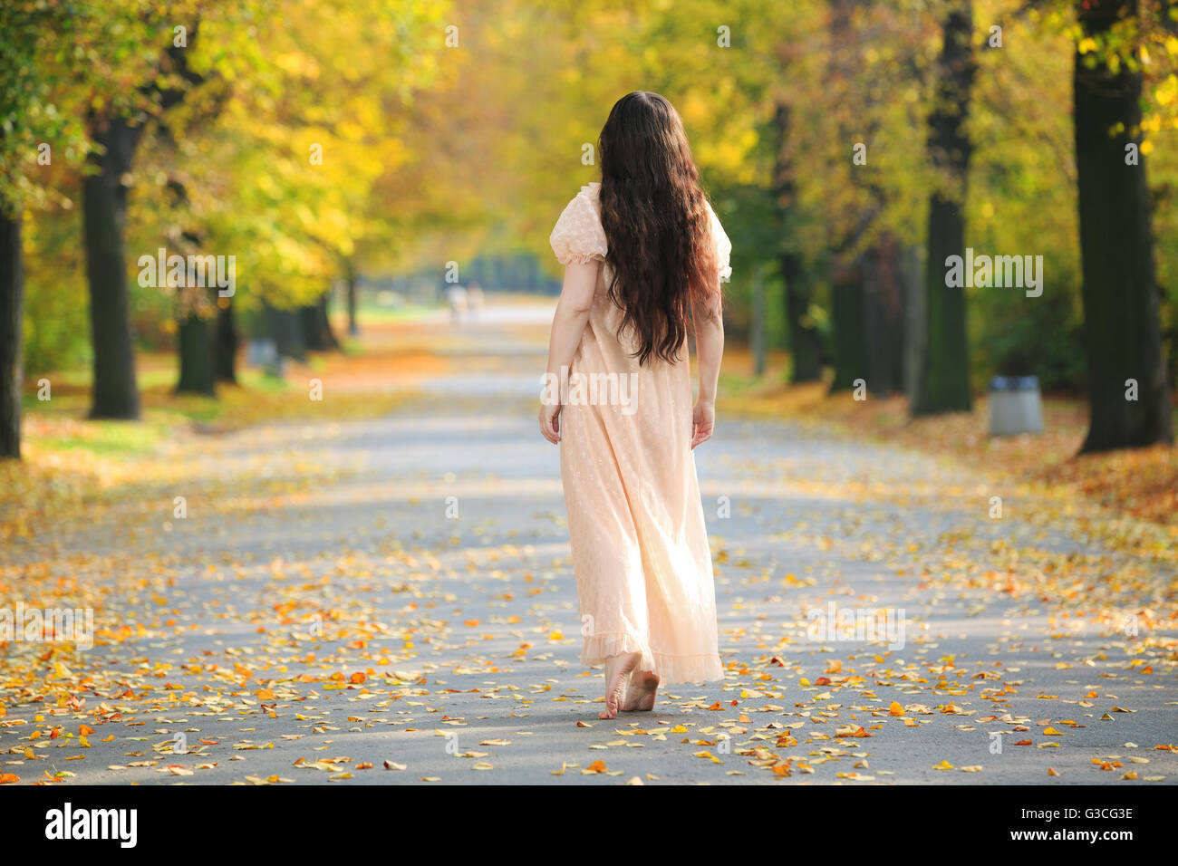 Mysterious lonely woman departing off into the distance Stock Photo - Alamy