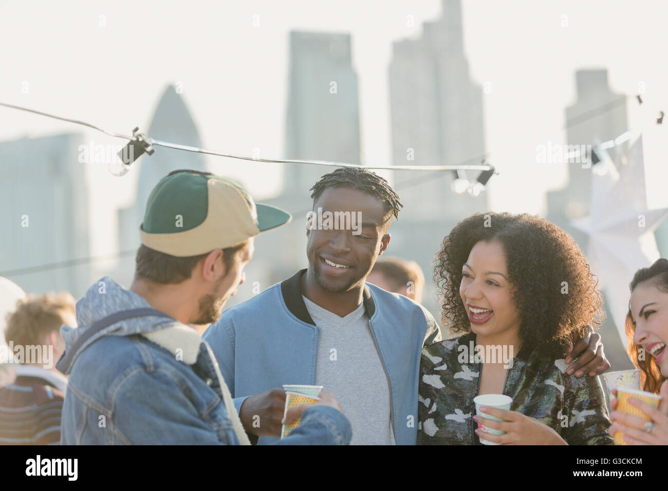 Young adult friends talking and drinking at rooftop party Stock Photo ...