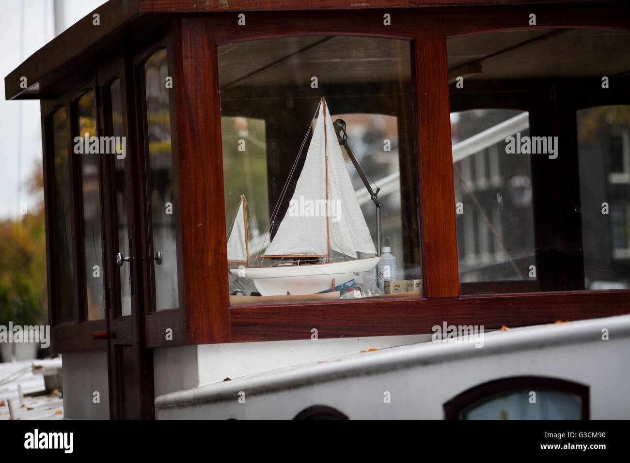 Small sailboat in the window of a real boat, located in achannel of ...