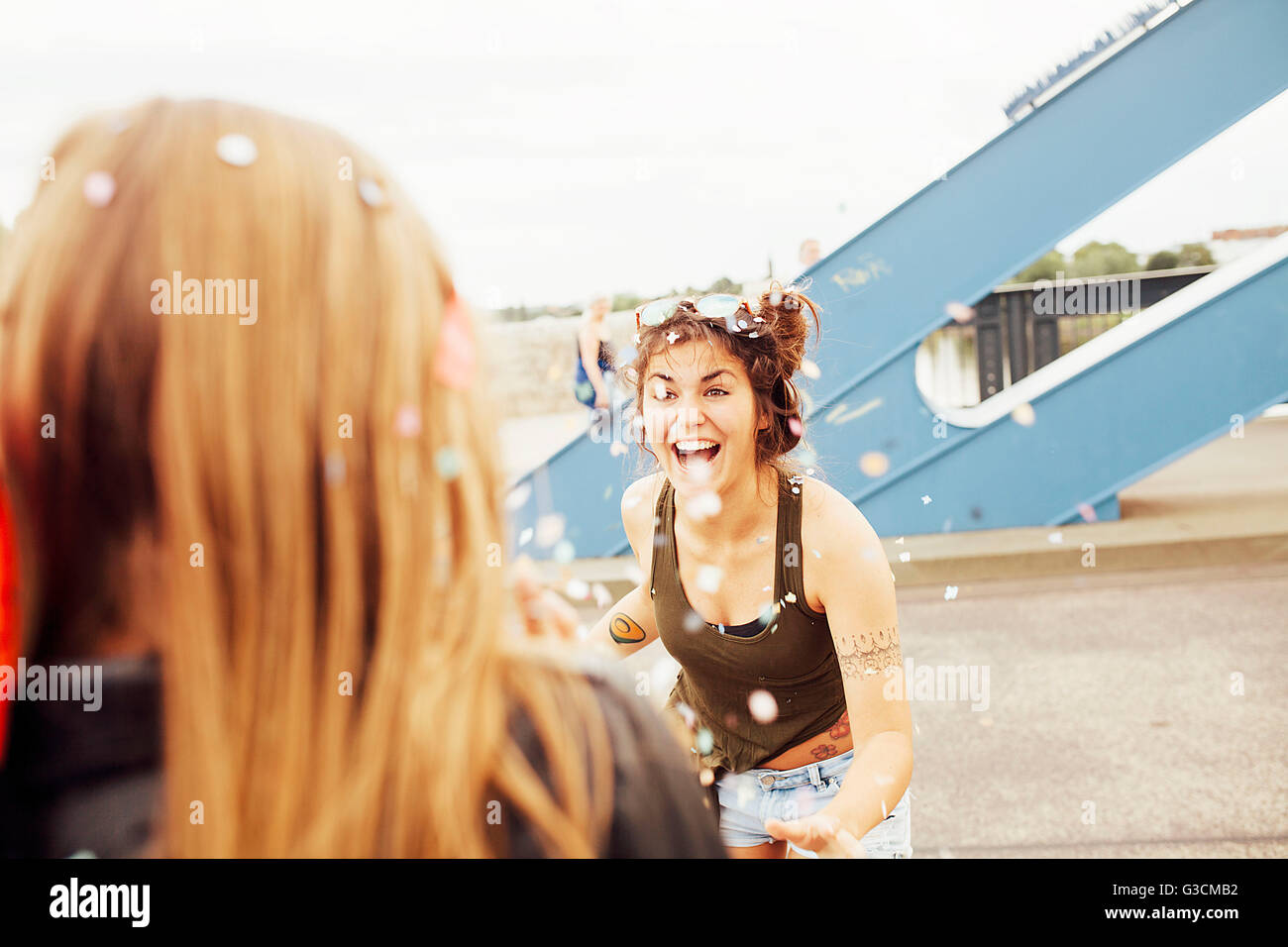 Young woman pelting others with confetti Stock Photo - Alamy