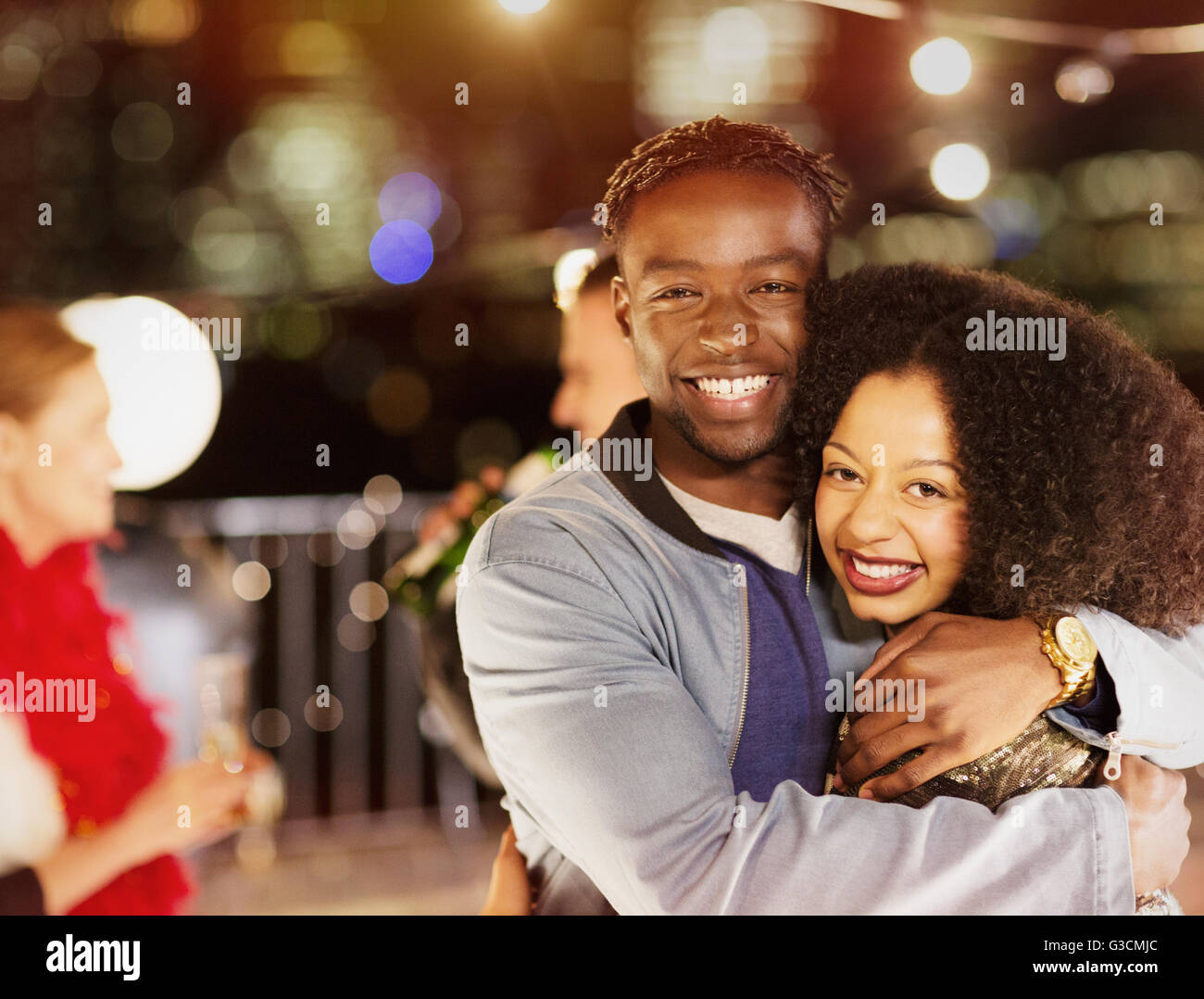 Portrait smiling young couple hugging at party Stock Photo - Alamy