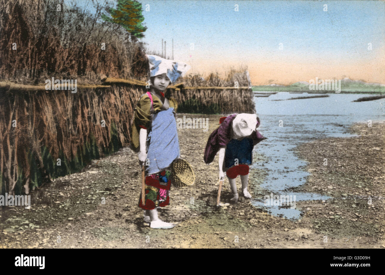 Japan, Two children digging for shellfish, low tide riverbed Stock ...