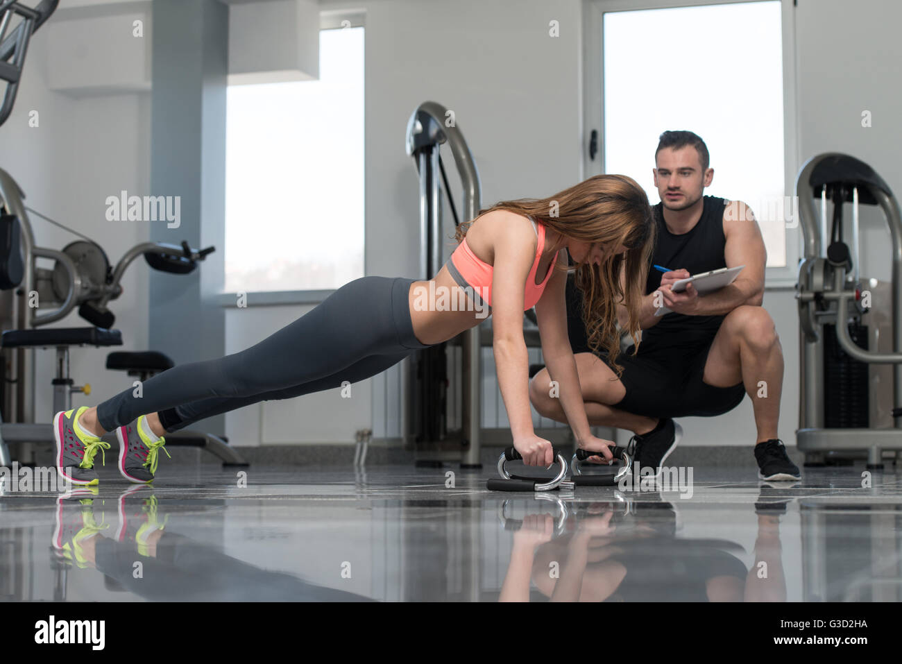 Personal Trainer Takes Notes While Young Woman Exercise Push-Up ...
