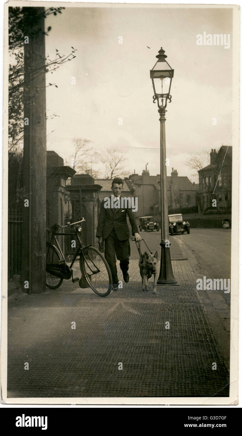Man taking an Alsatian dog for a walk Stock Photo - Alamy