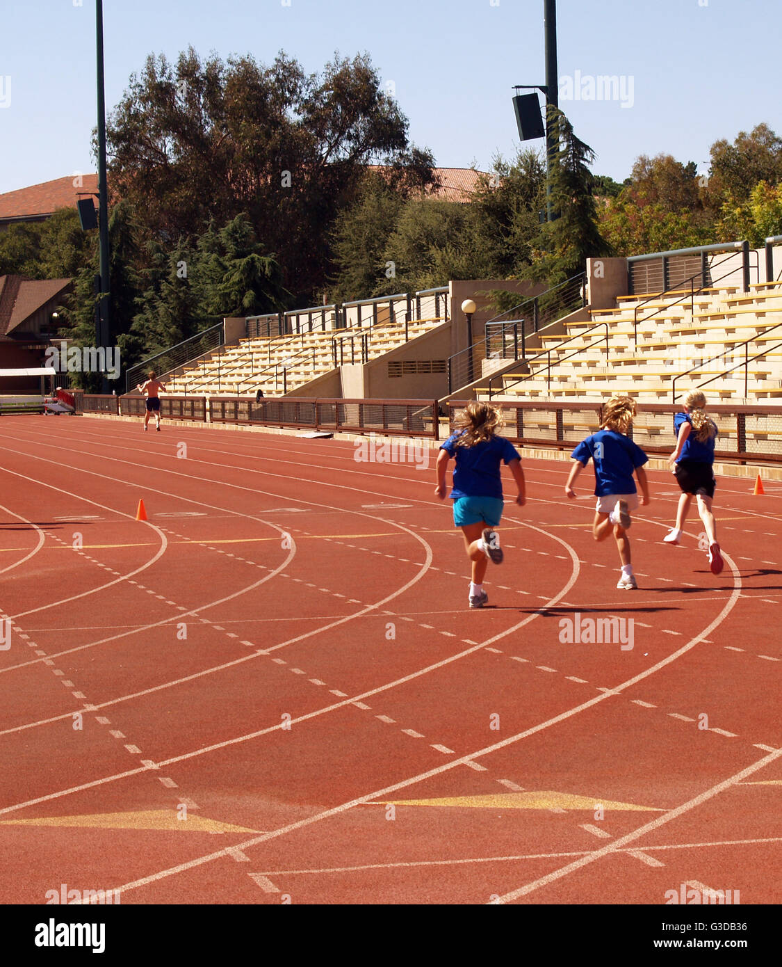 three young girls in shorts and shirts running on track Stock Photo - Alamy