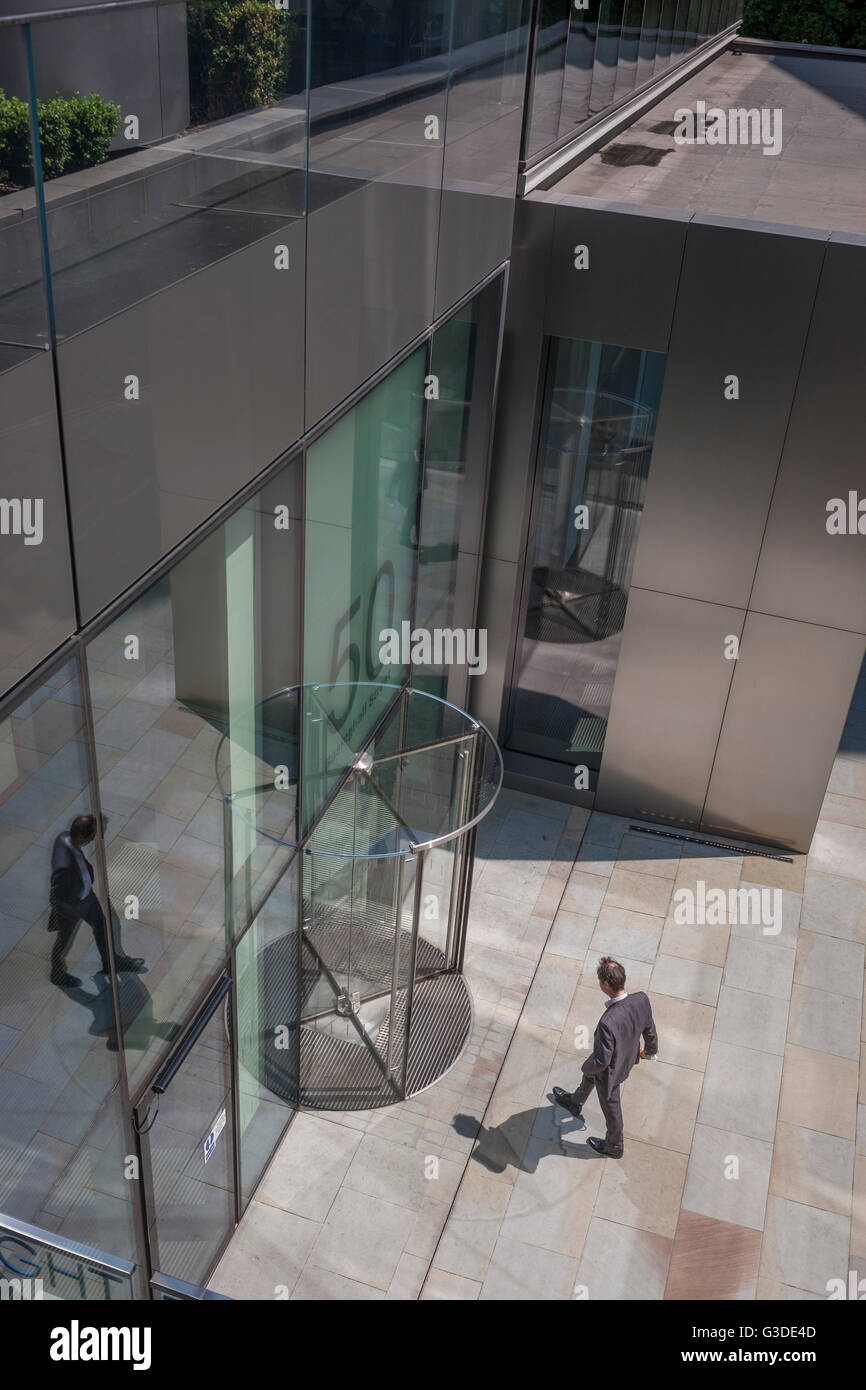 An aerial view of a City worker entering a revolving door of corporate ...