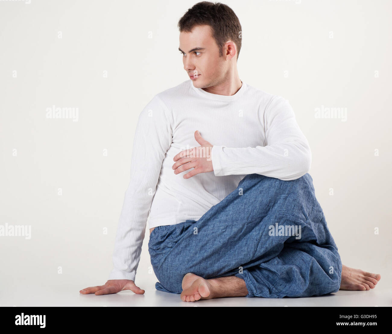 healthy young man doing yoga. Spine twisting pose Stock Photo - Alamy