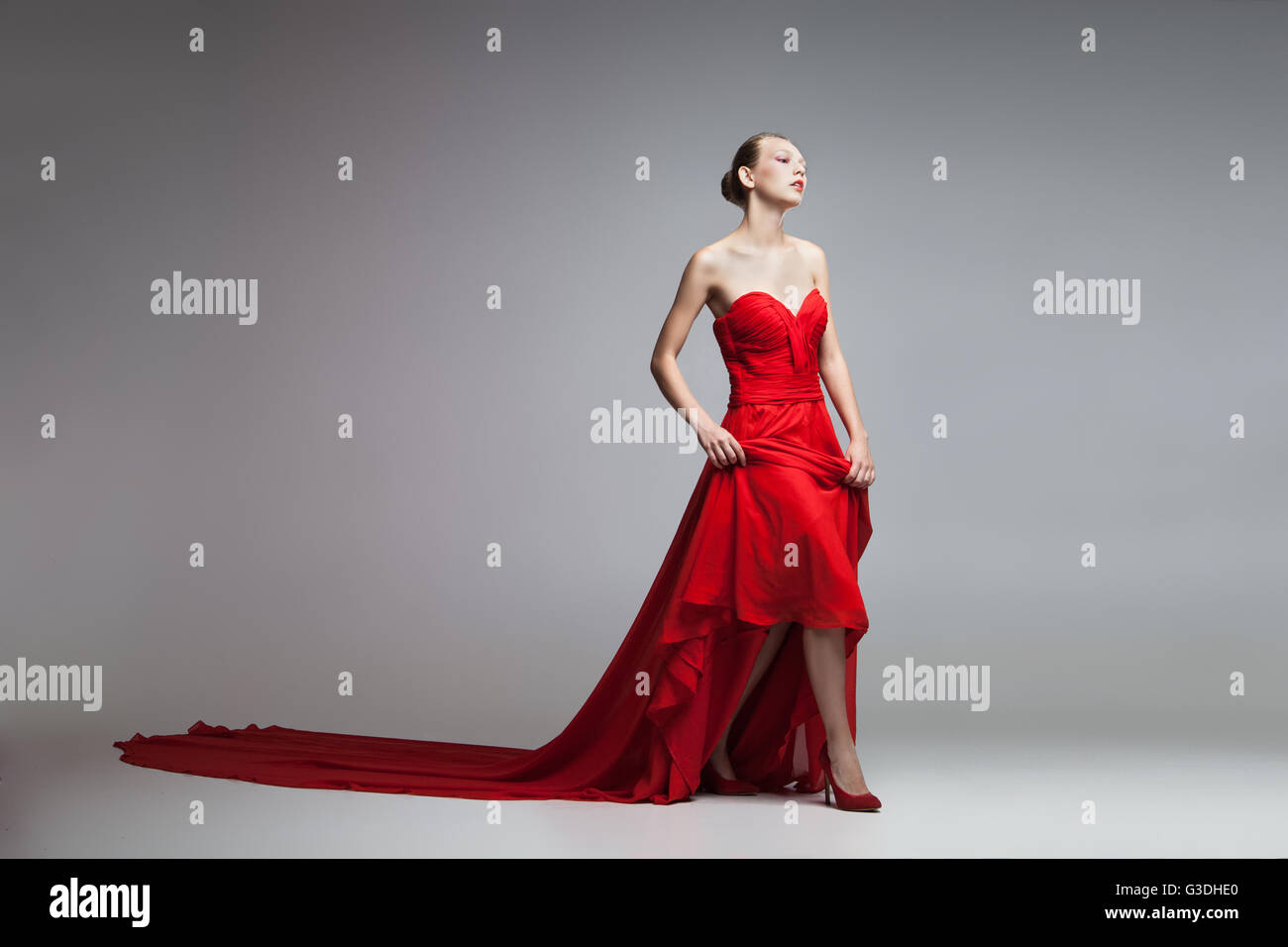 Young model in long red dress Stock Photo - Alamy