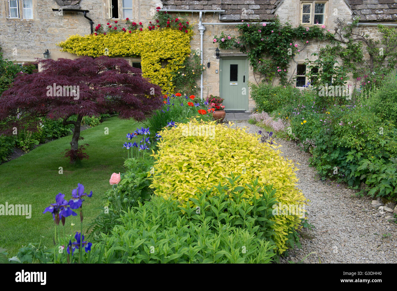 Seventeenth century stone cottage garden in Bibury in spring. Cotswolds ...