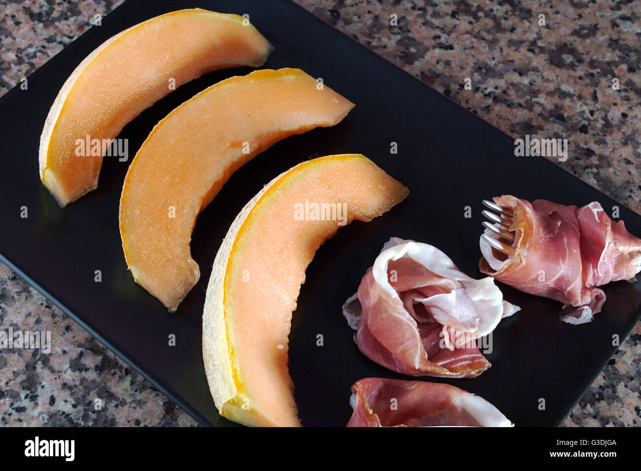 Slices of fresh melon with roses of Parma Italian ham, as typical ...