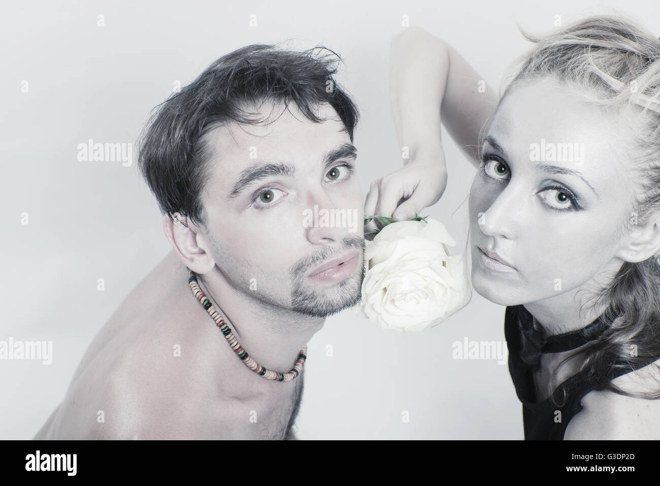 Young couple in love with a white rose and silver make-up closeup Stock ...