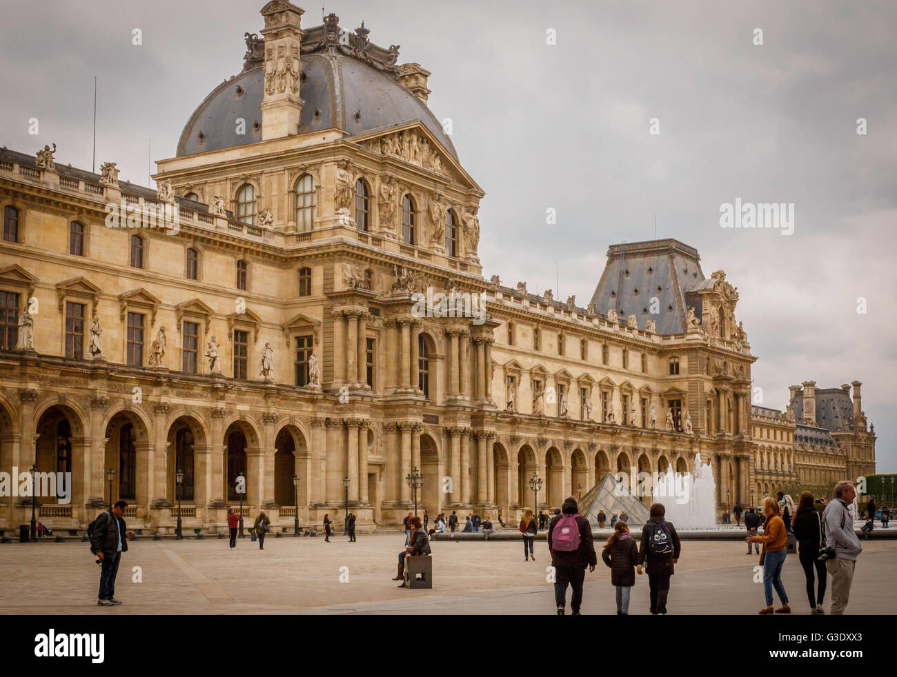 Tourists strolling around the courtyard at The Louvre with one of the ...