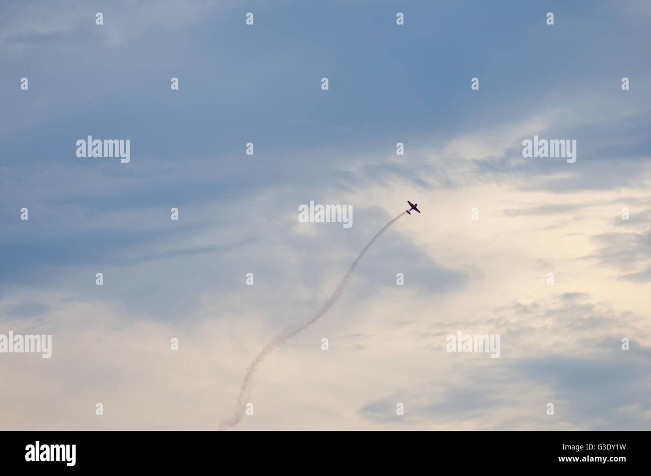 Acrobatic plane aircraft with smoke behind on blue sky Stock Photo - Alamy